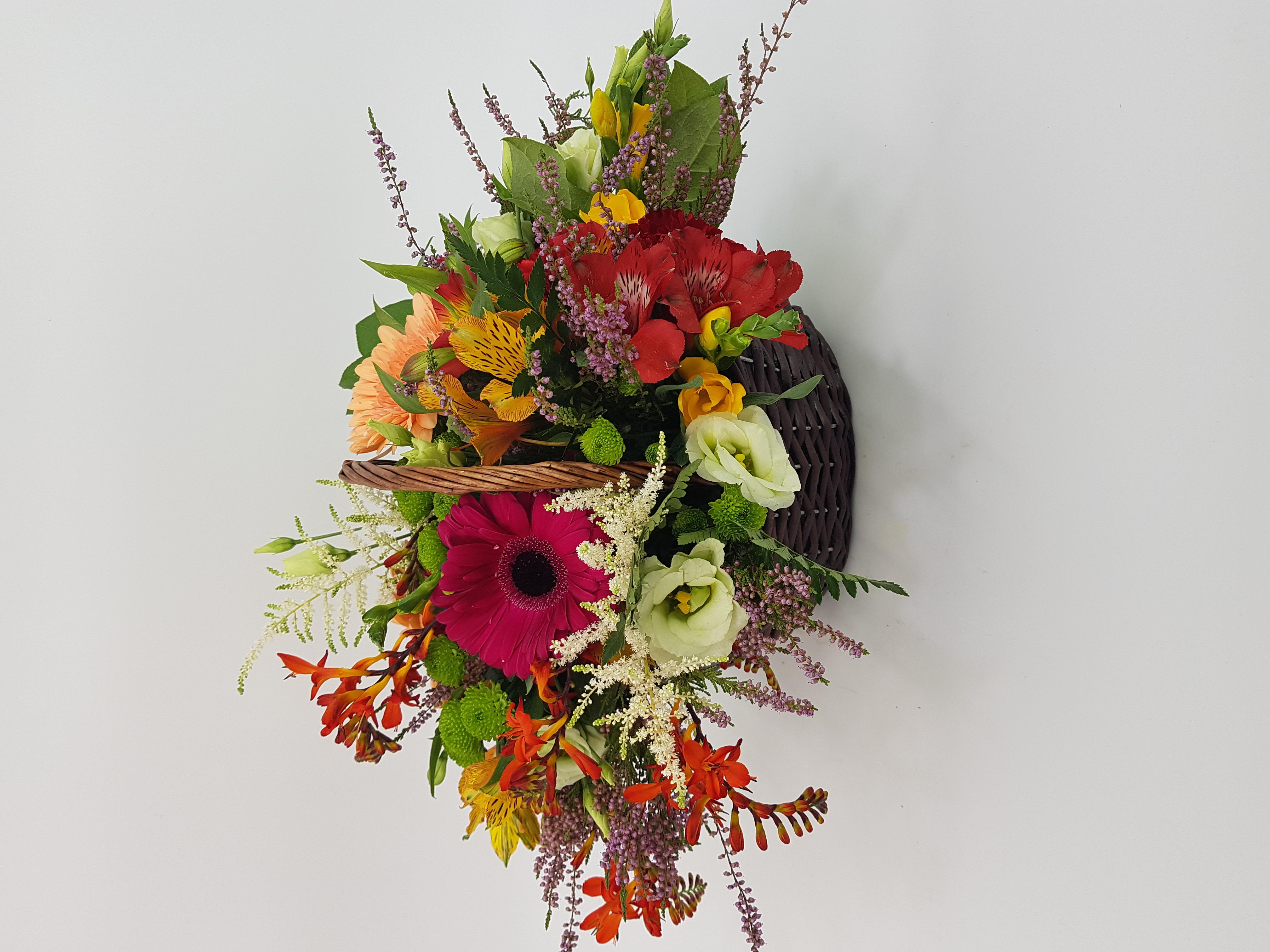 Rustic basket with fresh and colored flowers